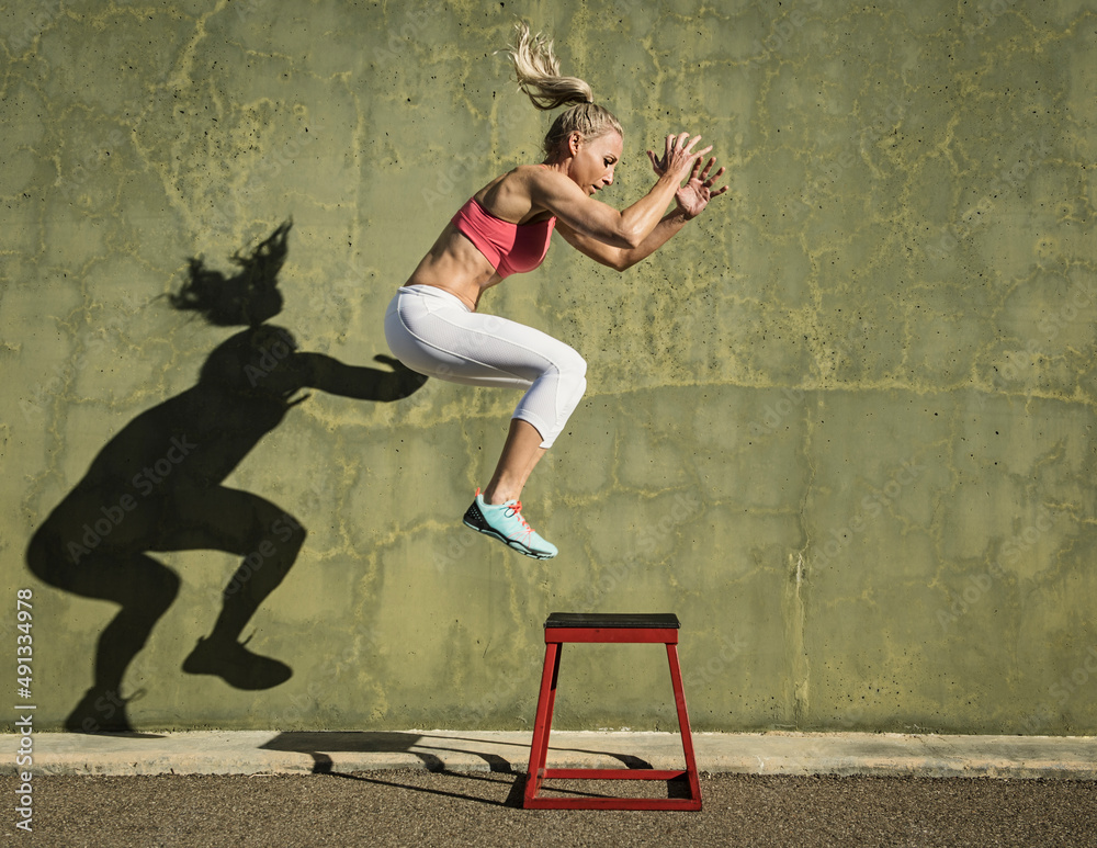 Athlete woman jumping over stool Stock Photo | Adobe Stock