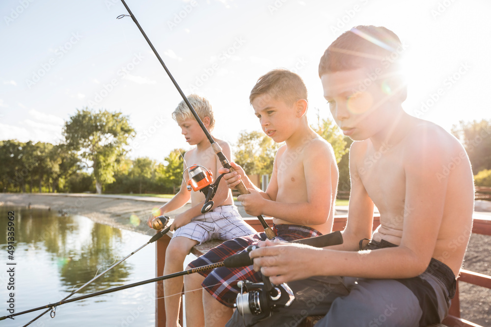 Three shirtless boys (8-9) fishing on lake Stock Photo | Adobe Stock