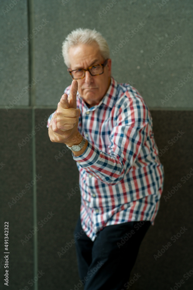 Old man with angry expression pointing a fake hand gun Stock Photo ...