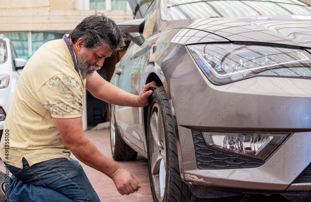 Man fixing a tire from his own car Stock Photo | Adobe Stock