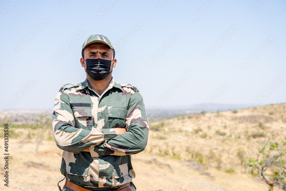 Young indian soldier standing arms crossed with medical face mask by ...