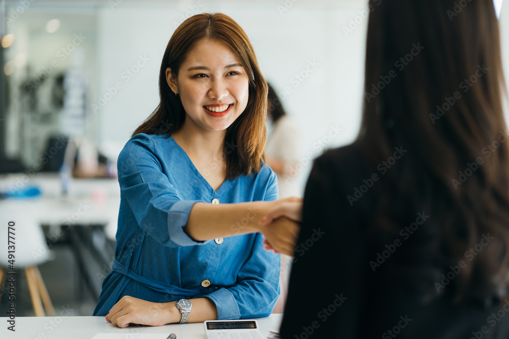 Portrait young Asian woman interviewer and interviewee shaking hands ...