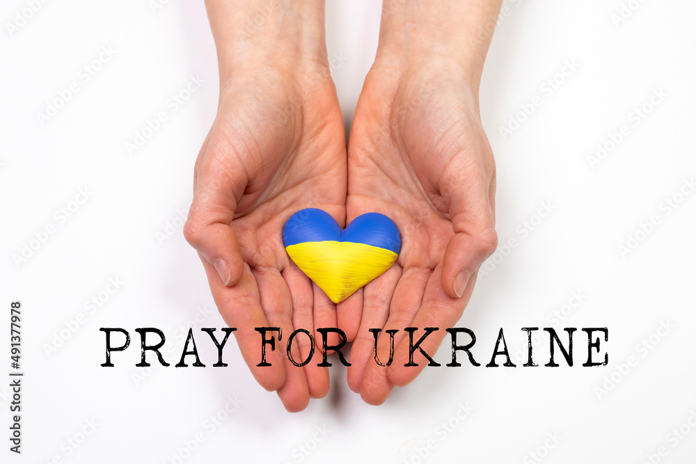 Heart flag of Ukraine in human hands. No war, peace for Ukraine concept ...