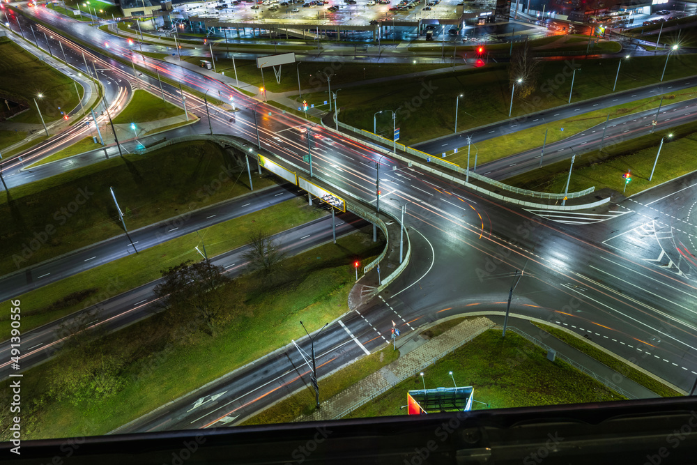 Night time on roundabout on road with cars with headlights on highway ...