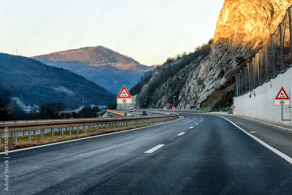 Scenic landscape with snow and drift road sign on mountain highway ...