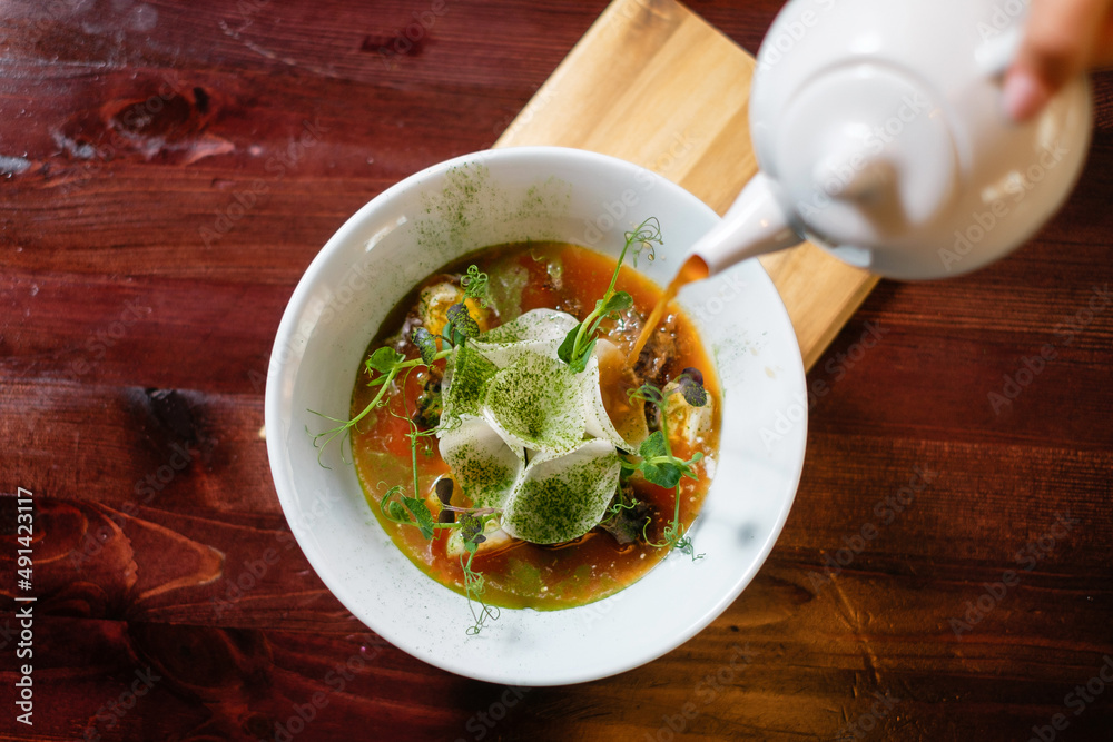 The process of pouring soup into a bowl top view. Original serving of ...