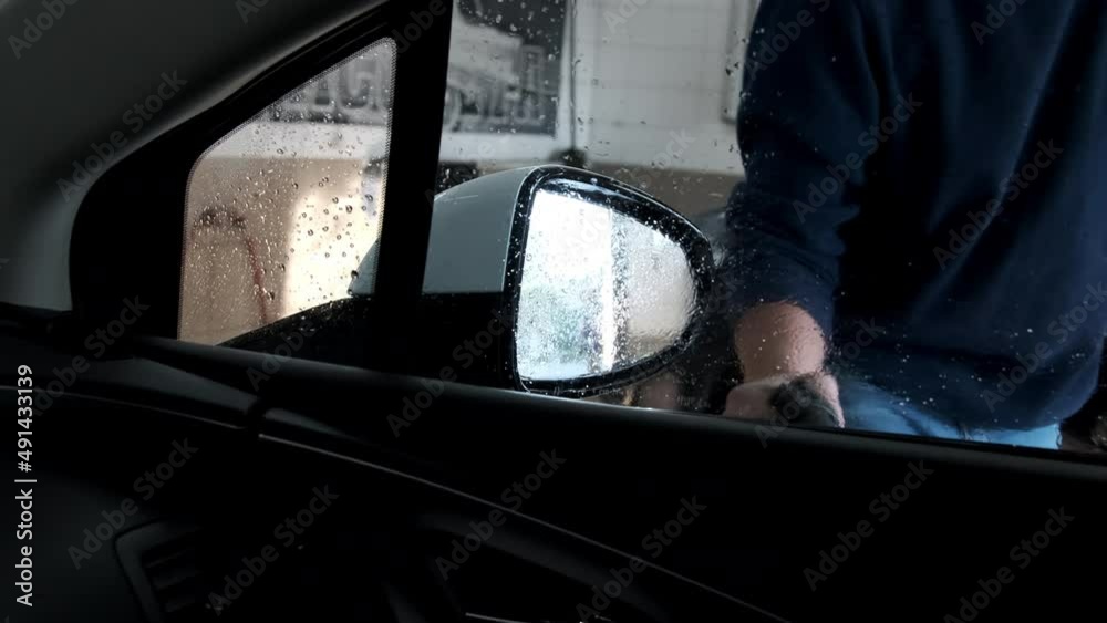 Vidéo Stock Man sprays water on window glass and side mirror of modern ...