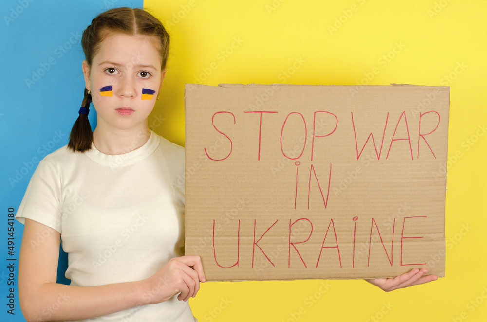 Ukrainian girl stands against the background of the Ukrainian flag with ...