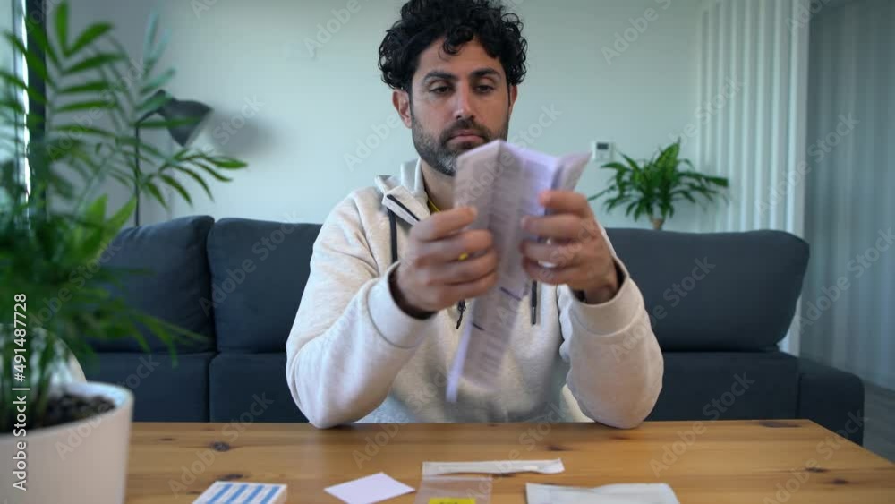 A caucasian man at home reading instructions on supply of Covid-19 ...