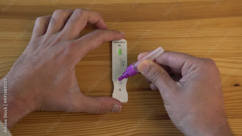 Man placing the sample into the covid-19 antigen diagnostic test ...