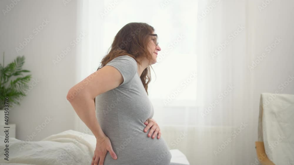 Vídeo do Stock: Pregnant woman experiences pain in back and abdomen ...