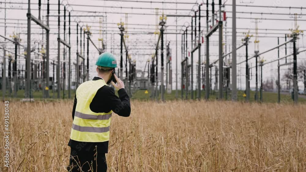 Electric engineer wearing helmet suit and safety vest at bad weather ...