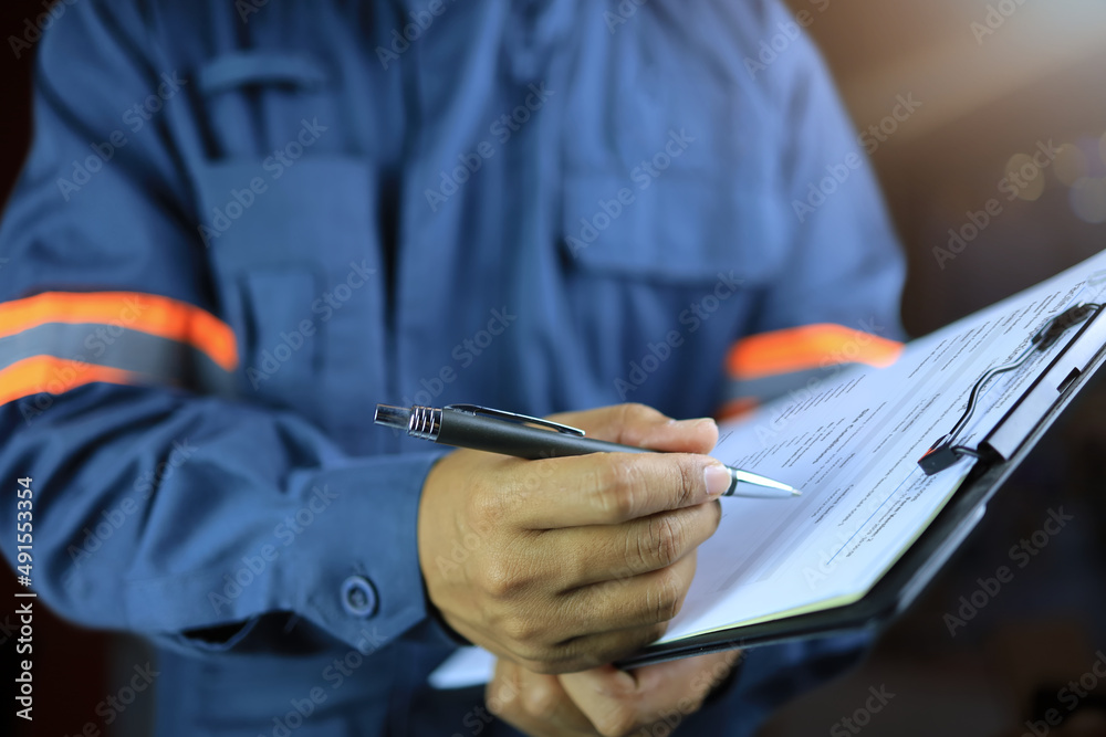 Side view, an auditor or specter holding a clipboard and checklist of ...