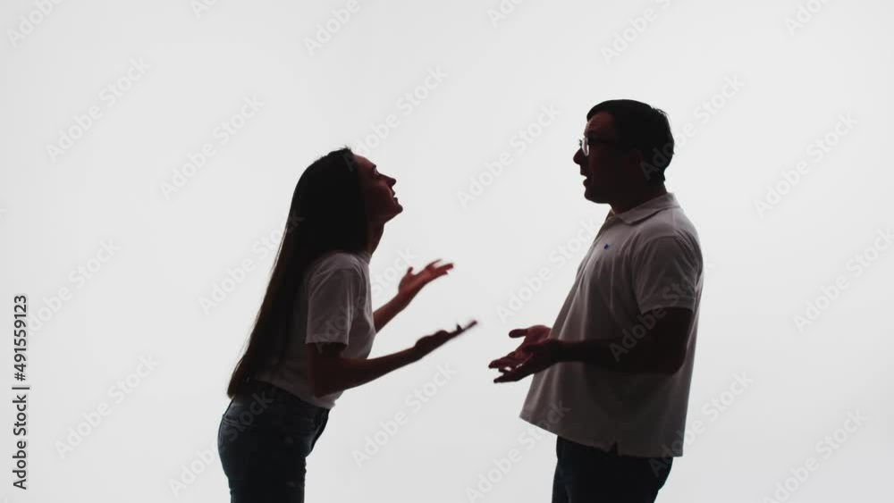 Silhouette of married couple, wife swearing and arguing with husband ...