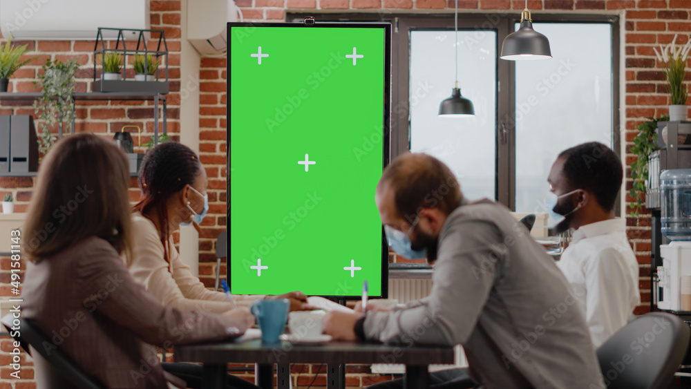 Team of diverse workmates working with vertically green screen on ...