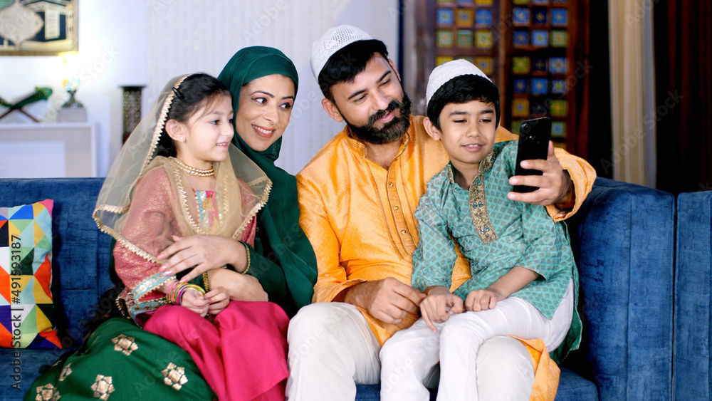 Fotografia do Stock: A joyful Muslim family making a video call on ...