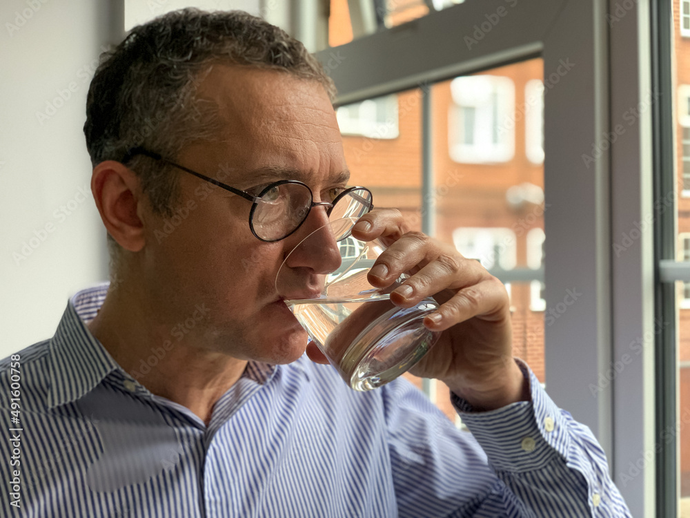 Middle aged man is drinking water to stay hydrated Thirsty man having ...