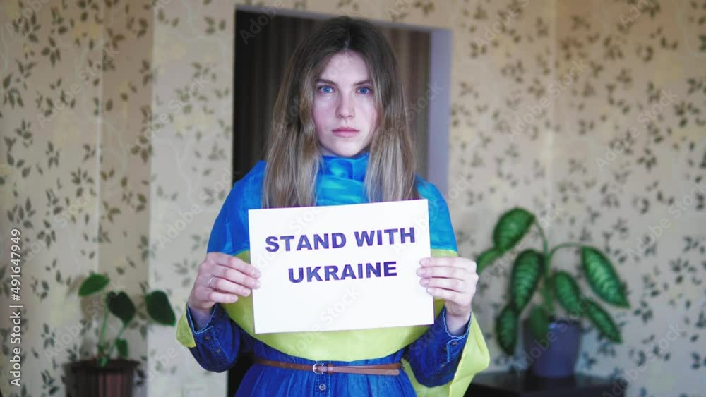 Upset Sad Ukrainian female with a flag protesting war conflict raises ...
