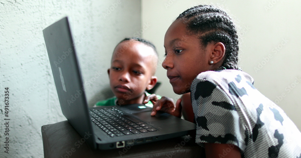 Children browsing the internet on laptop. little brother and sister in ...