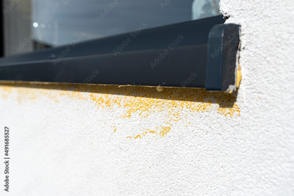 Yellow mounting foam filled under the window sill, white plaster is ...
