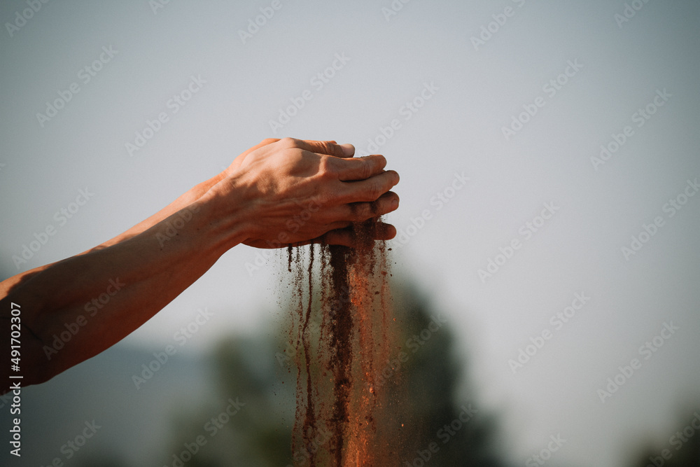 Young dancer performing and playing with red sand ground in the ...