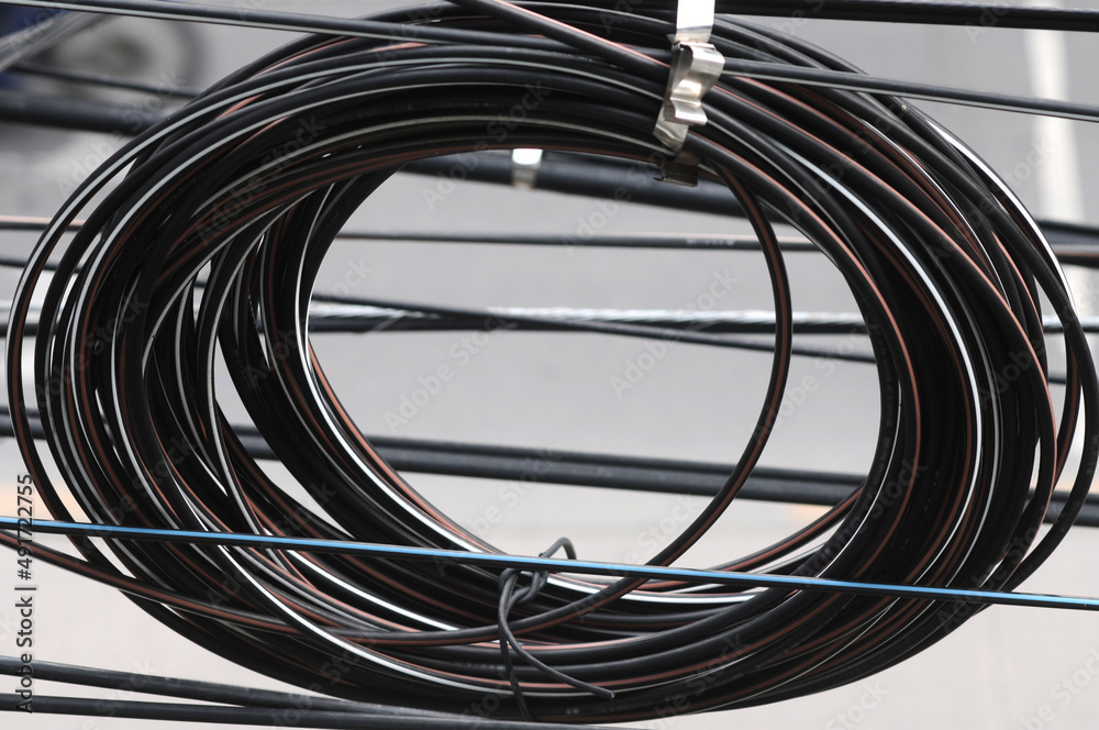 fiberglass internet cable. hanging on the electric pole in the street ...