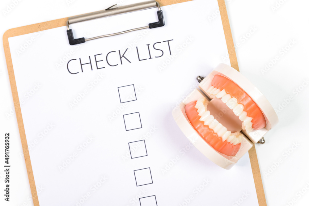 Checklist and dentures to check your health. Stock Photo | Adobe Stock