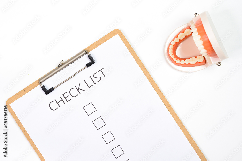 Checklist and dentures to check your health. Stock Photo | Adobe Stock