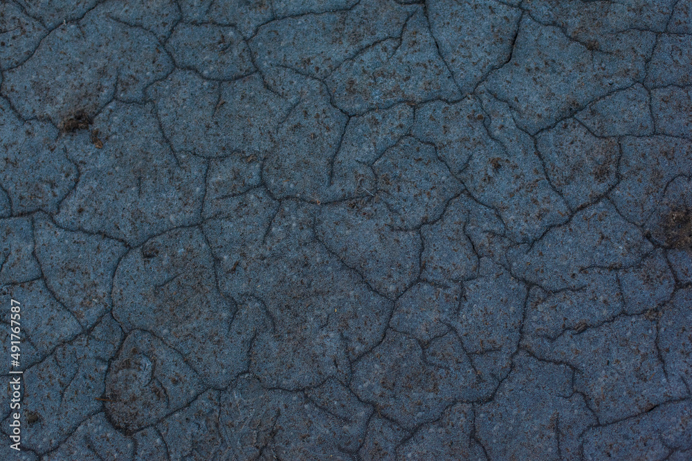 Texture of the dried earth. Dark gray background with cracks and ...