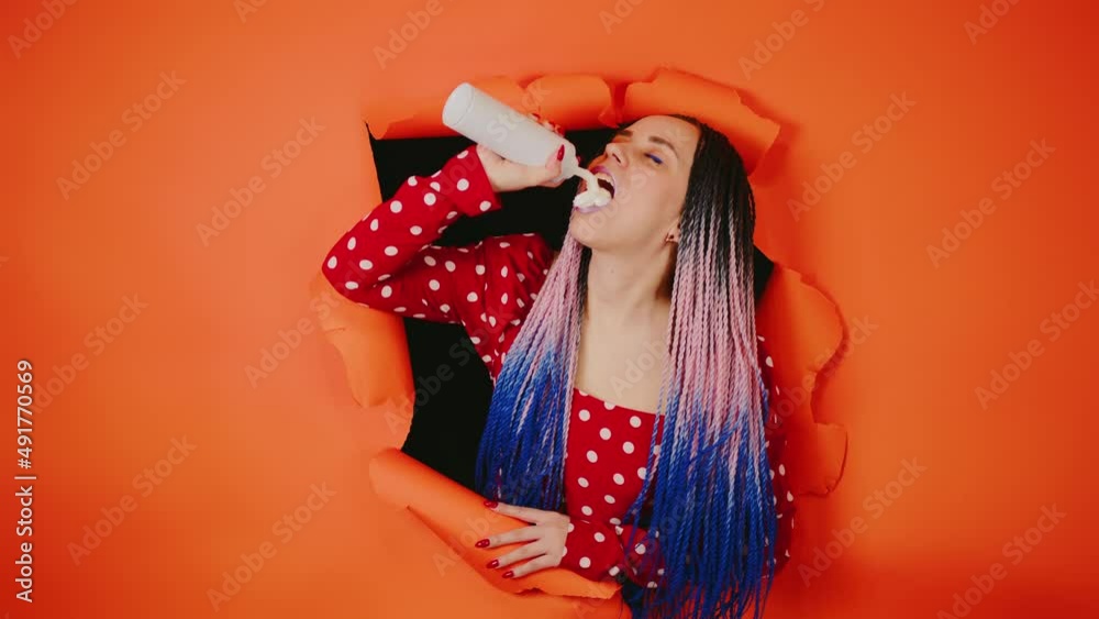 Beautiful woman pressing whipped cream into mouth. A stylish girl in a ...