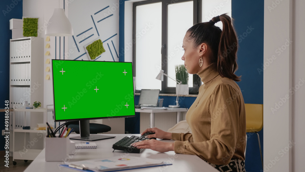 Business woman using computer with green screen in startup office ...
