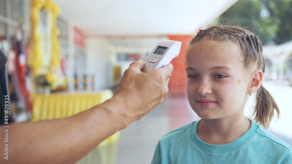Temperature check at a supermarket of little girl, grocery store with ...