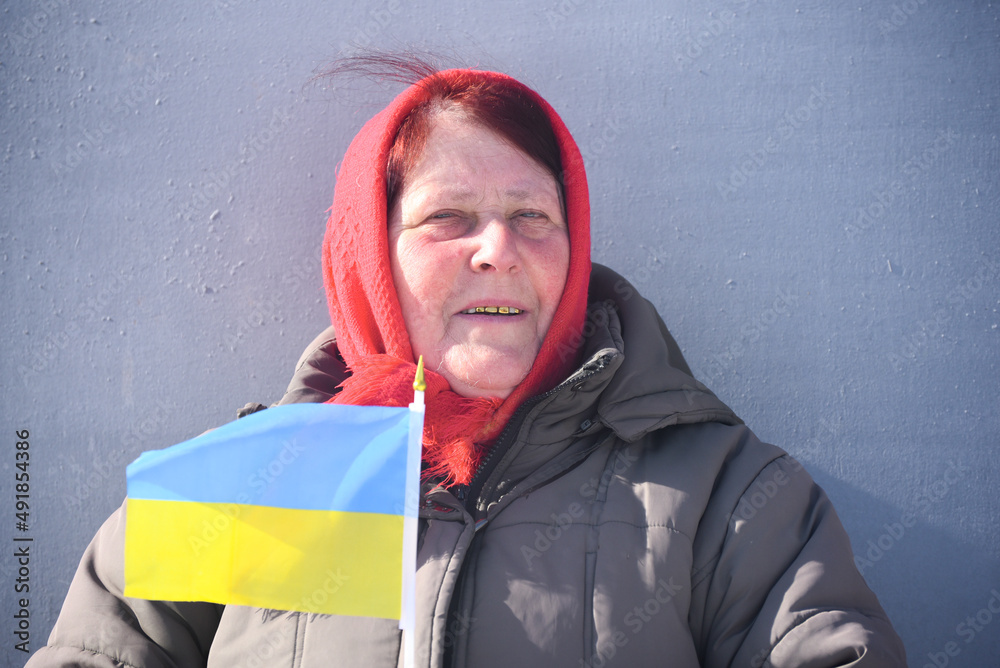 Portrait of old Ukrainian women of 60 years old holding frag of Ukraine ...