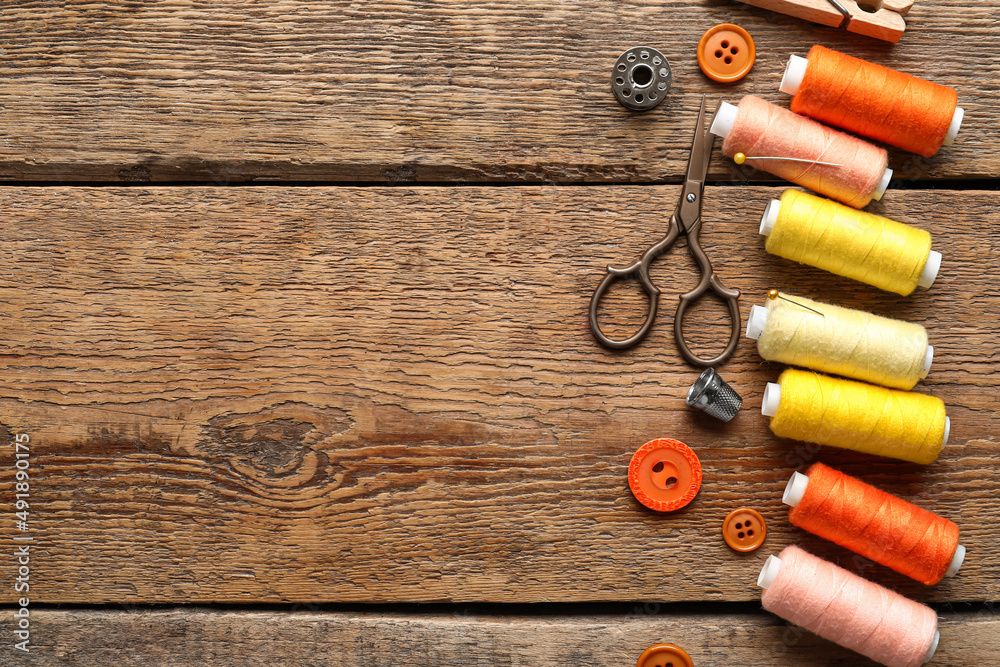 Sewing threads with buttons and scissors on wooden background Stock ...