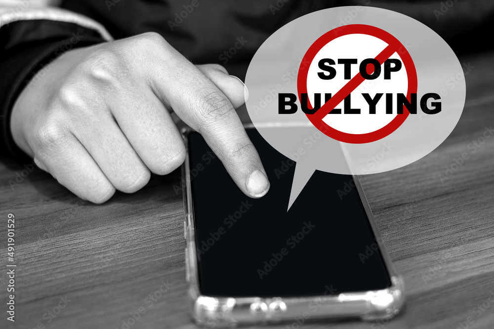 Teenager boy using mobile phone typing telling people to stop online ...