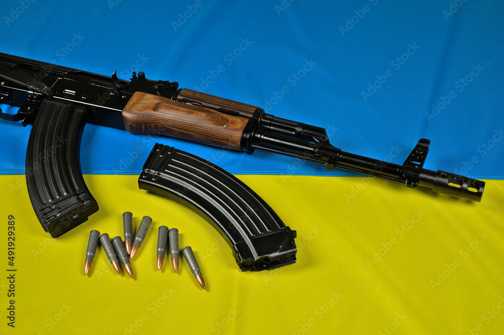 Ak-47 rifle, magazines and ammunition lying on a blue-yellow Ukrainian ...