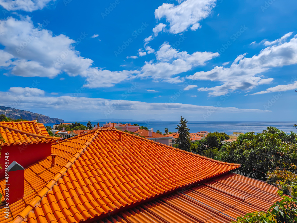 Blue sky view over a red clay tiles rooftop of a private house in ...