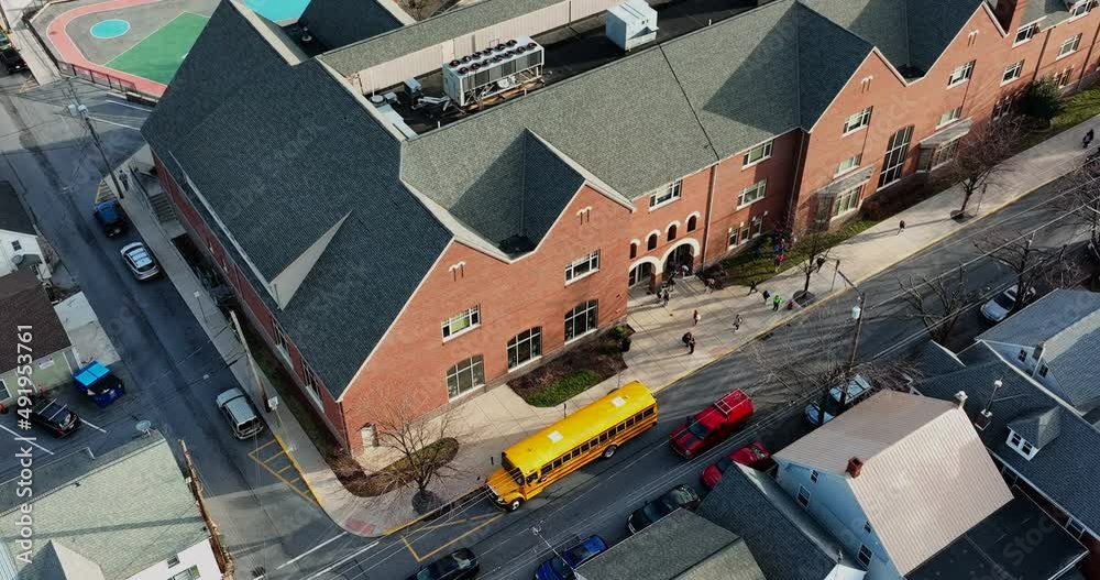 Modern American school building with school bus drop off. Playground ...