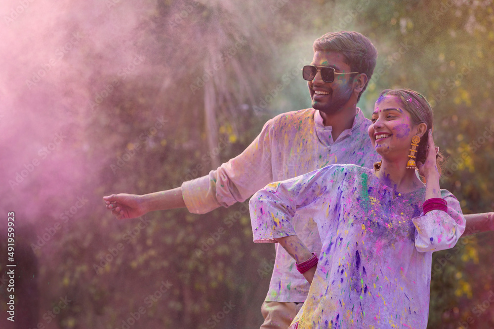 Happy Indian young couple enjoying Holi festival by dancing Stock Photo ...