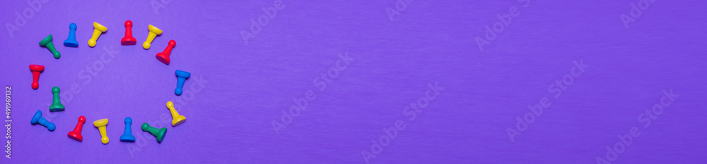 Colored game chips and playing cubes laid out on a purple background in ...