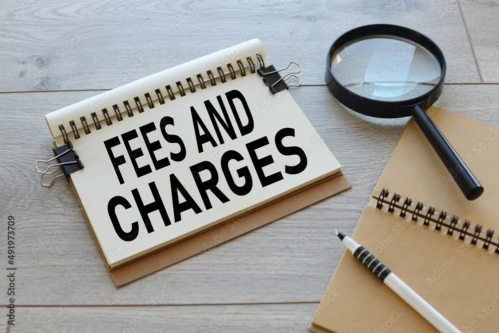 FEES CHARGED wooden light table. magnifying glass.text on open notepad ...