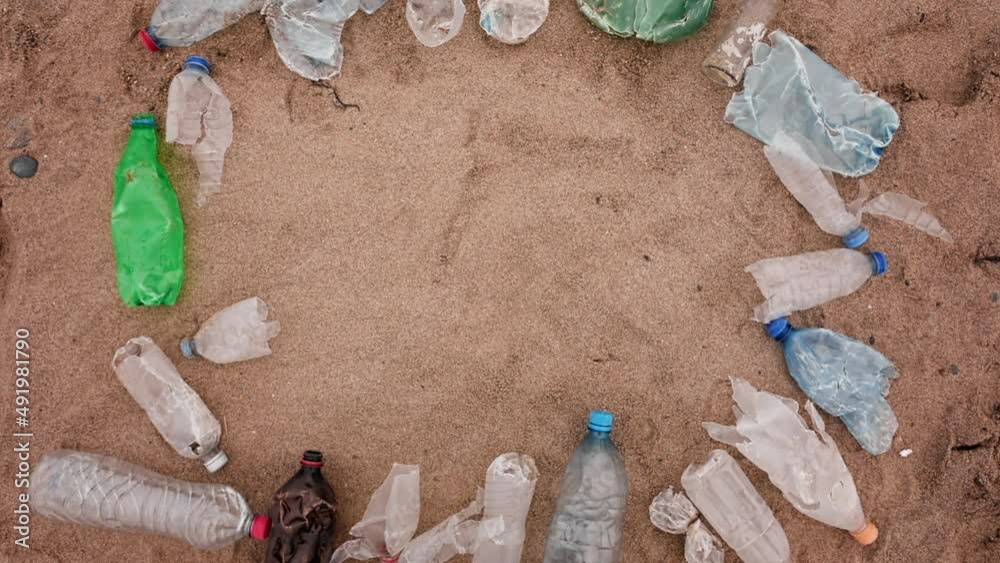 Ecological disaster. Trash frame from plastic bottles on a sandy beach ...