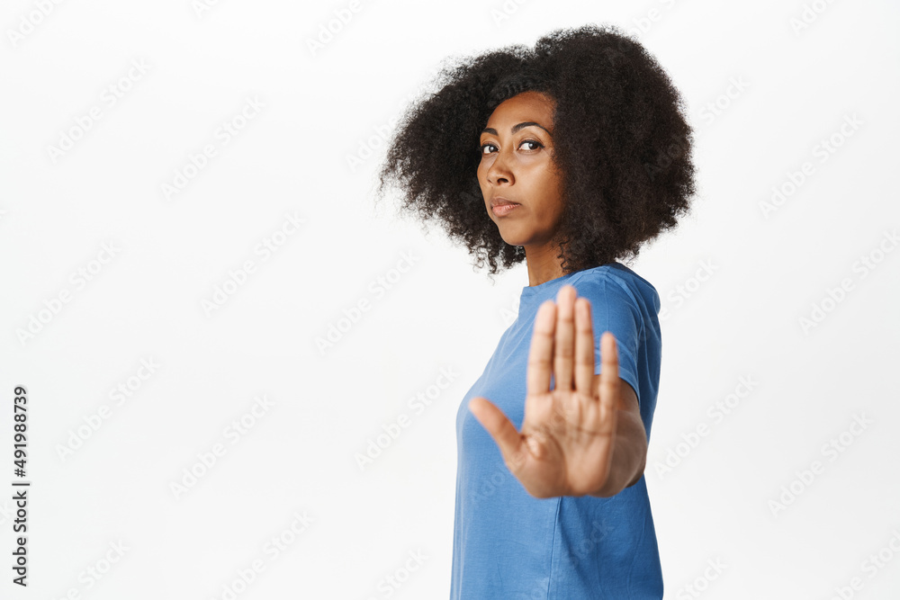 Serious african american woman stretching out one hand, showing taboo ...
