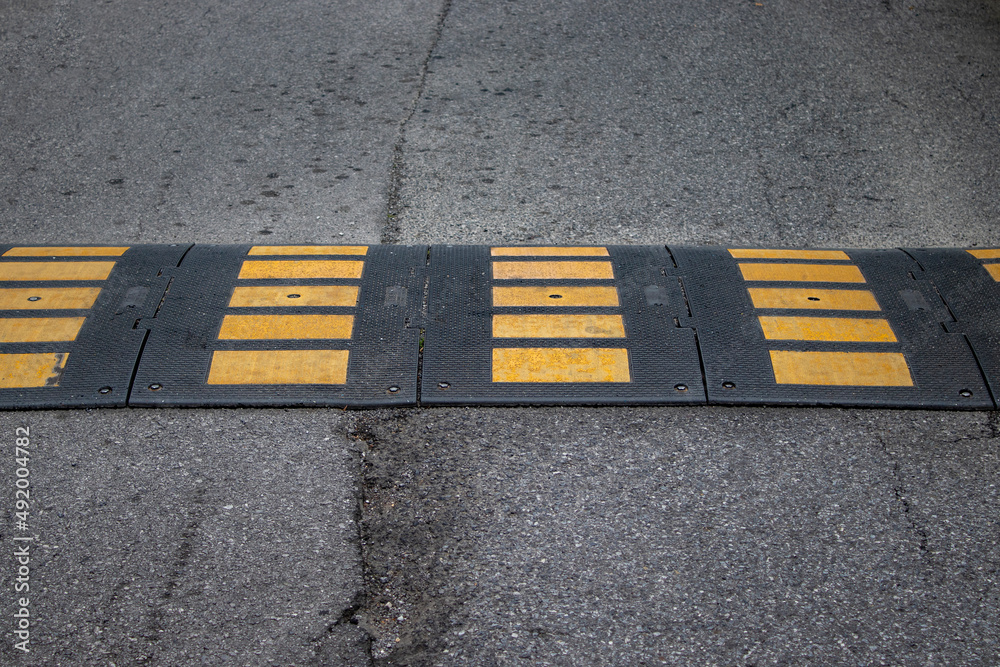 Road safety speed bump on asphalt road. Speed bumps are used to Stock ...