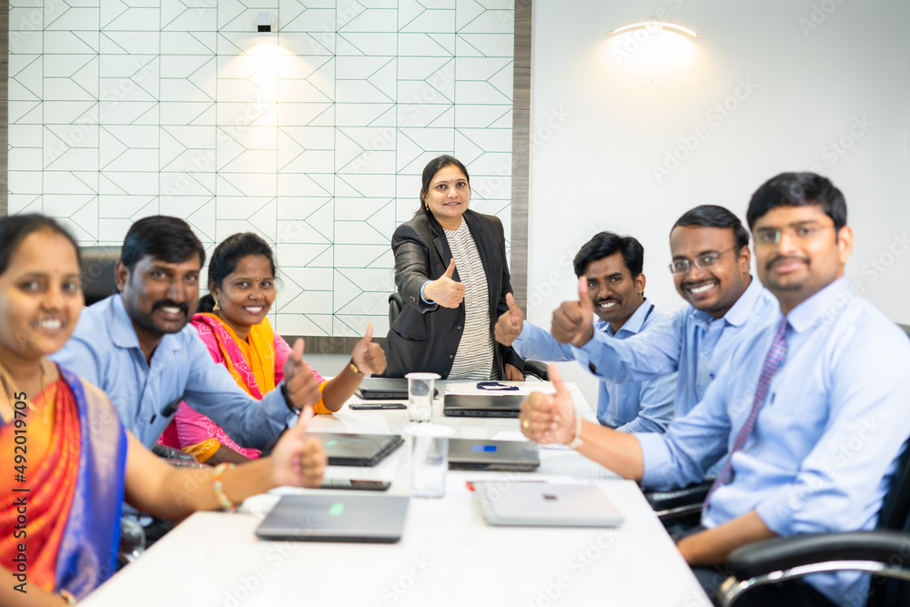 smiling confident corporate employees with uniform showing thumbs up by ...