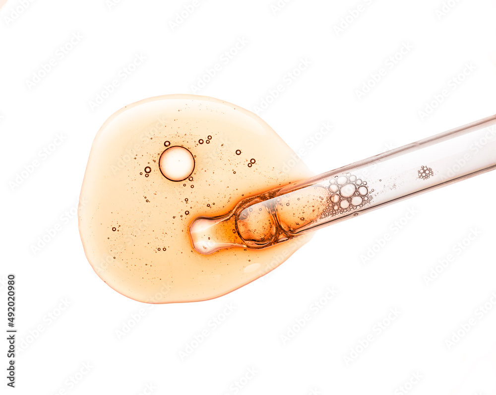 Liquid yellow-orange retinol or vitamin c gel or serum with a dropper ...