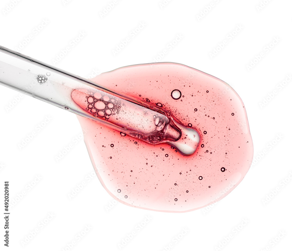Liquid red pink retinol or vitamin c gel or serum with a dropper on a ...