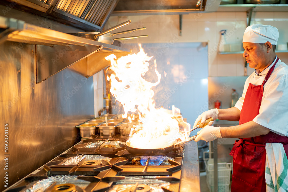 Indian chef cooking in industrial kitchen with the burning pan Stock ...