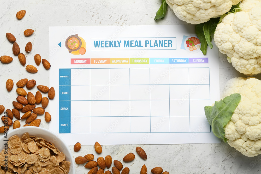 Weekly meal planner and different healthy products on light background ...