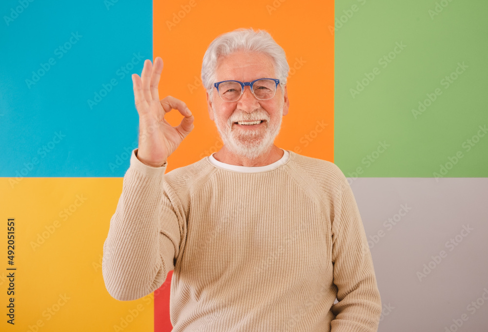 Handsome adult senior man gesturing optimist sign looking at camera ...